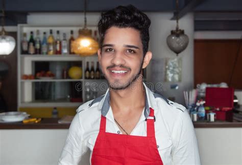 Hispanic Waiter With Cup Of Coffee Showing Thumb At Restaurant Stock