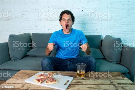 축 하 그의 축구 팀 점수를 보고 목표 그의 소파에 가정에서 그것을 보면서 행복 한 젊은 백인 축구 팬 경기 스포츠에 대한 스톡 사진 및 기타 이미지 Istock