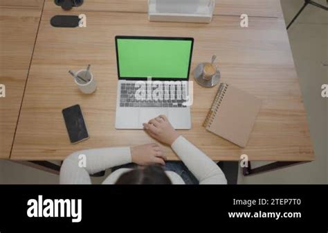 Office Table With Green Screen Laptop Computer And Female Hands Taping Or Scrolling On Pad