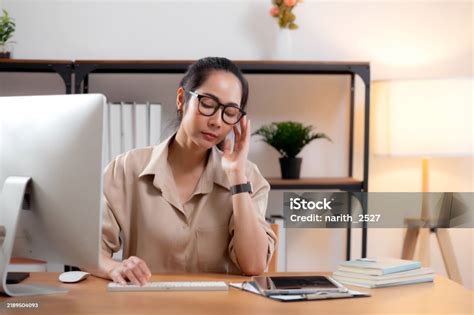 젊은 아시아 비즈니스 여성은 데스크탑 컴퓨터로 작업하면서 현대 홈 오피스의 책상에서 금융 계획을 생각하고 사업가 계획 및 일 비즈니스 및 금융에 대해 사려 깊습니다 40