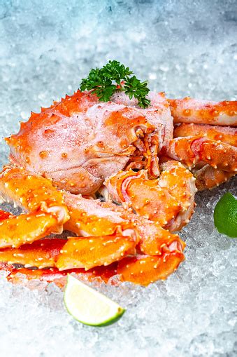 큰 빨간 캄차카 게 얼음에 거짓말 발톱 체리 레몬과 라임의 조각은 둥근 슬라이스 주위에 거짓말 신선한 허브와 함께 빛 상단 측면보기 주위 게에 대한 스톡 사진 및 기타