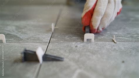 Laying Tiles On The Floor The Man Is Installing Ceramic Tiles For Fixing At The Same Distance