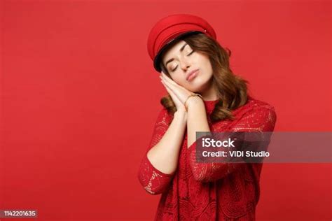 레이스 드레스에 편안한 젊은 여자 캡 유지 눈 폐쇄 스튜디오에서 밝은 빨간색 배경에 고립 된 얼굴 근처 손으로 자 고 사람들은 진심으로 감정 라이프 스타일 개념입니다 복사