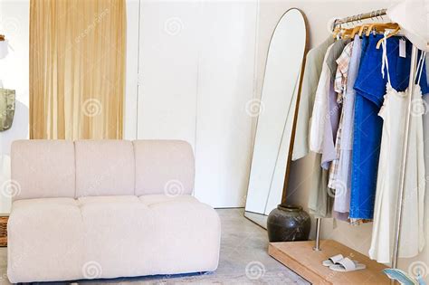 Fitting Room With Presentation Of Cloths Collection With Sofa And Mirrror In Retail Fashion Shop