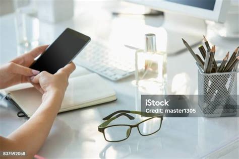 현대 사무실 인테리어에 컴퓨터에서 작업 하는 동안 스마트 휴대 전화를 사용 하 여 여성의 손을 클로즈업 그래픽 사용자 인터페이스에 대한 스톡 사진 및 기타 이미지 Istock