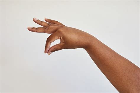 빈 모형 공간을 들고 회색 배경에 스튜디오에서 흑인 여성과 함께 손 손가락 풍미 제스처 손가락 및 꼬집음은 요리사로 요리하는 동안 소금 한 꼬집을 추가하는 여성과 함께 30