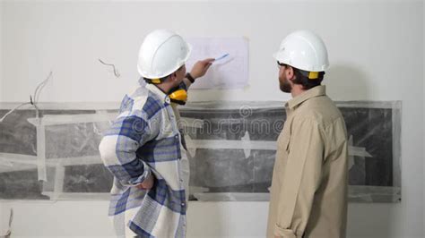 Two Installers Of The Ventilation System Look At The Drawing On The Wall Stock Footage Video