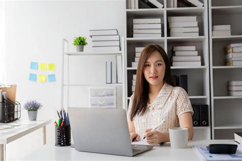 사무실에서 계산 테이블 회계 보고서 회사 재무 통계 및 분석 연구 아이디어에 대한 재무 수학을 수행하기 위해 계산기와 노트북을 사용하여 아시아 여성 직원 검사 보기에 대한