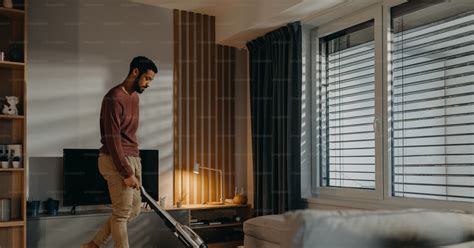 거실에서 카펫을 진공 청소하는 젊은 남자 사진 Unsplash의 현대 거실 이미지