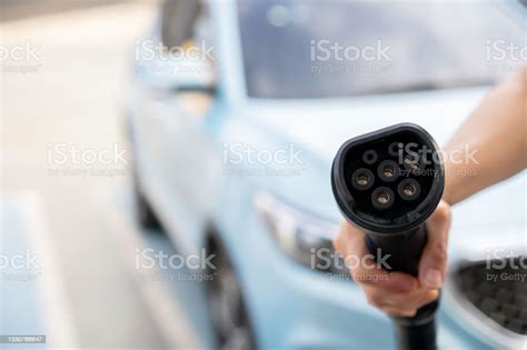 Ev 충전 커넥터를 들고 있는 여성 교통수단에 대한 스톡 사진 및 기타 이미지 교통수단 급유 녹색 기술 Istock