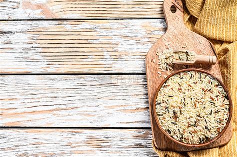 茉莉花棕色红色和黑色的米饭在碗里混合米和稻子白色背景前视图本空间