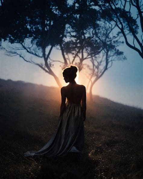 Фото Девушка стоит на фоне дерева на закате солнца By Christopher James