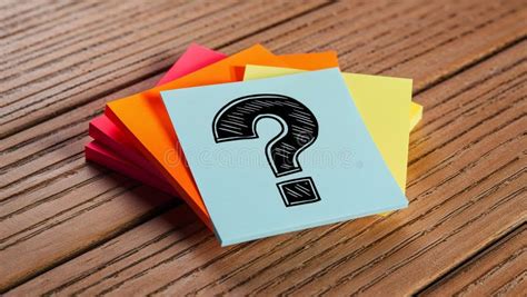 question mark drawn on a sticky note placed on a wooden table stock