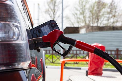 연료로 차를 채 웁 니다 차는 주유소에서 가솔린으로 채워진다 주유소 펌프 남자는 노즐을 들고 자동차 연료로 가솔린을 급 유 필드의 제한 된 깊이입니다 흐린 이미지 0명에