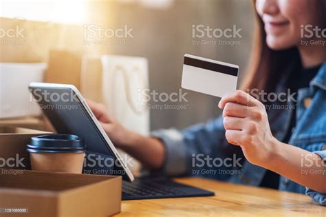 테이블에 우편 소포 상자와 쇼핑 가방온라인 쇼핑을위한 태블릿 Pc와 신용 카드를 사용하는 젊은 아시아 여성 신용 카드에 대한 스톡 사진 및 기타 이미지 Istock