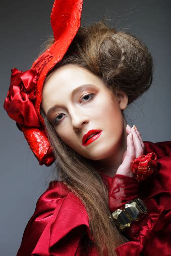 빨간 카니발 의상과 주홍색 모자를 쓴 예쁜 여자가 회색 배경에 포즈를 취합니다 20 24세에 대한 스톡 사진 및 기타 이미지 20 24세 관능 금발 머리 Istock