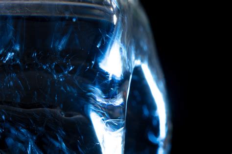 매크로 클로즈업에서 얼음은 차가운 배경을 배경으로 추상적인 패턴과 질감을 드러냅니다 얼음 서리와 물에서 태어난 금이 간 결정