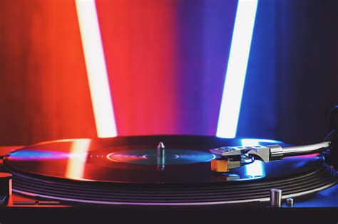 턴테이블 비닐 레코드 플레이어 Dj가 재생 음악을 혼합 하는 사운드 기술 레드 비닐 레코드 레이블 밝은 파티 빨간색과 파란색 빛 플레이트의 표면을 조명 스타일러스 바늘 0