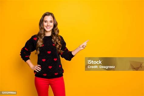 놀라운 낮은 쇼핑 시즌 가격을 조언 손가락 빈 공간을 나타내는 재미 예쁜 아가씨의 사진은 마음 패턴 풀오버 빨간 바지 고립 된 노란색 색상 배경을 착용 가리키기에 대한 스톡