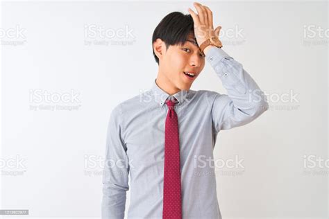 고립 된 흰색 배경 위에 서있는 우아한 넥타이를 입은 중국 사업가는 실수로 머리에 손을 대고 놀랐습니다 잊어 버린 나쁜 메모리
