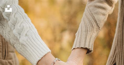 흰색 니트 스웨터를 입은 여자가 갈색 재킷을 입은 남자와 손을 잡고 있다 사진 Unsplash의 무료 갈색 이미지