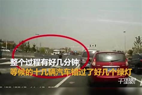 司机下车扶盲人过马路 十多辆车静静等了几个红绿灯 盲人 马路 红绿灯