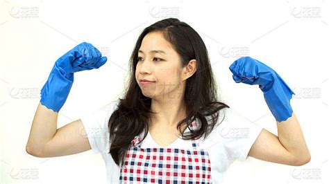 坚强的亚洲妻子戴着清洁手套和围裙