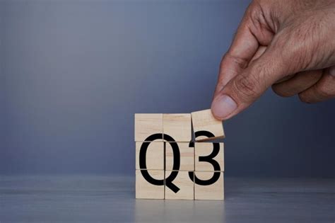 premium photo hand placing wooden cube with text q3 third quarter