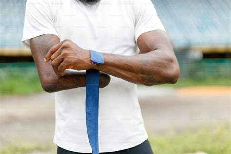 턱수염을 기르고 흰 셔츠를 입은 남자가 파란 넥타이를 매고 있다 사진 Unsplash의 올림픽 종목 이미지