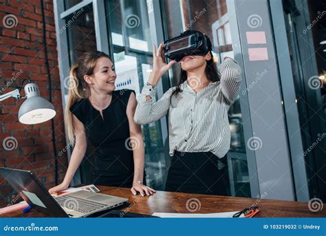Two Female Application Developers Testing A New App Designed For Vr Headset Standing In Modern
