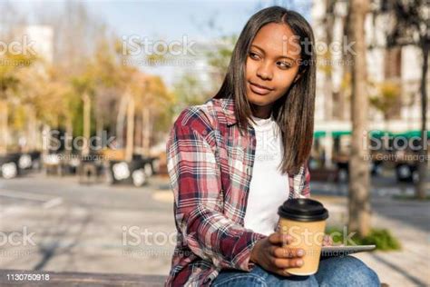 화창한 날에 테이크 아웃 커피를 들고 있는 동안 태블릿 Pc와 도시에서 야외 앉아 젊은 아름 다운 아프리카계 미국인 여자 갈색 머리에 대한 스톡 사진 및 기타 이미지