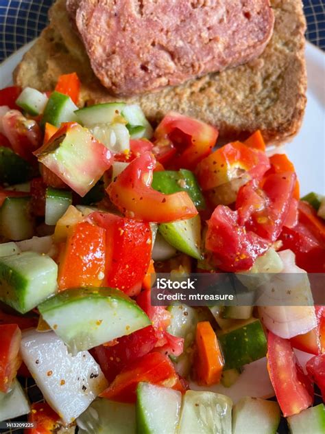 다진 과일과 채소 다진 당근 토마토 오이 샐러드가 통밀 빵에 얇게 썬 옥수수 쇠고기와 함께 제공되는 향신료와 섞인 수제 샐러드의 푸른 테두리 접시의 전체 프레임 이미지 높은