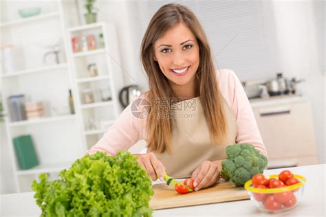 在厨房做素食的美丽的年轻女子高清图片下载 正版图片502793407 摄图网