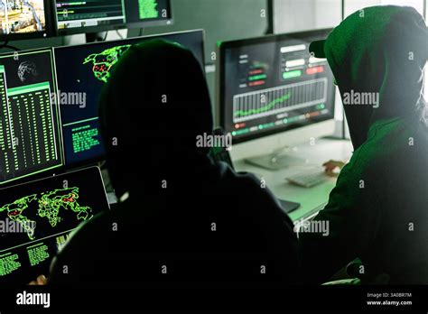 hackers working on computers showing world maps and security camera