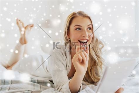 休息灵感创造力舒适和人的概念 快乐的年轻女人带着笔和笔记本在雪地上在家里的床上做梦高清摄影大图 千库网
