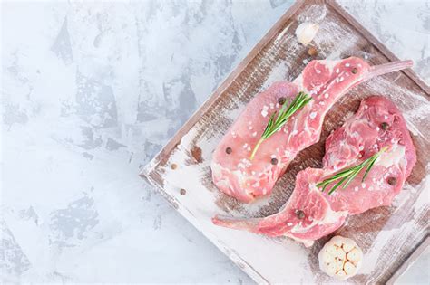 생 고기의 두 조각이 나무 스탠드에 거짓말 후추 마늘 로즈마리가 포함 된 돼지고기 스테이크 회색 돌 배경에 공간을 복사 합니다 텍스트에 대 한 장소 사진 0명에 대한 스톡