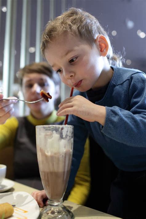 Il Ragazzo Beve Il Cocktail Del Cioccolato Al Latte Fotografia Stock