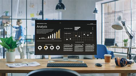 크리에이티브 모던 오피스의 데스크톱 컴퓨터 촬영 모니터 화면은 그래프 차트 소프트웨어 Ui와 회사 성장 데이터를 보여줍니다 배경에서 책을 찾고 젊은 전문 개념에 대한 스톡
