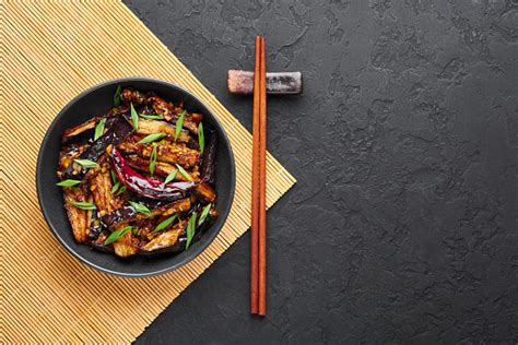 사천 가지 는 어두운 슬레이트 배경에 검은 그릇에 볶는다 가지 볶음 요리는 튀긴 가지 고추 후추 다른 소스와 중국 요리 요리입니다 공간을 복사합니다 맨 위 보기 0명에 대한