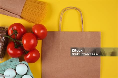 카피 스페이스 모형과 노란색 배경에 음식 기부와 종이 가방 플랫 누워 파스타 신선한 채소 통조림 식품 유기농 계란 및 오일 기부 식품 개념 비접촉식 배달 Charitable