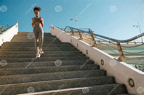 Active Female Athlete In Sportswear Running On Steps Outdoors On A