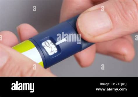 Close Up On Hands Turn Knob On Insulin Pen And Dial Up Insulin Dose For