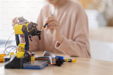 smart asian female programer learning robot arm ai coding electronic