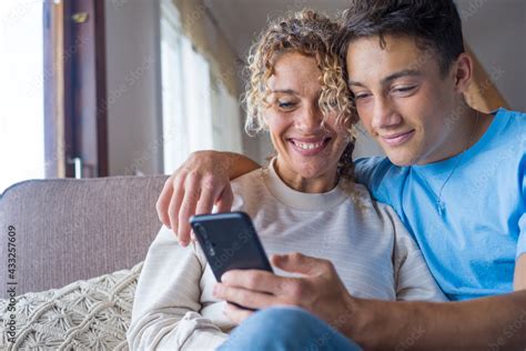 Foto De Smiling Middle Aged 40s Mother Rest With Grown Up Son Using Smartphone Together Happy