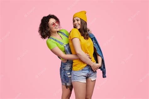 Premium Photo Female Hipsters Hugging And Looking At Each Other