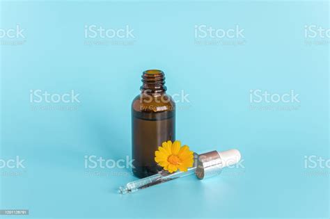 파란색 배경에 누워 유리 파이펫과 오렌지 꽃 금송화오픈 갈색 드롭퍼 병에 에센셜 오일 컨셉 천연 오가닉 뷰티 화장품 제품 0명에 대한 스톡 사진 및 기타 이미지 Istock
