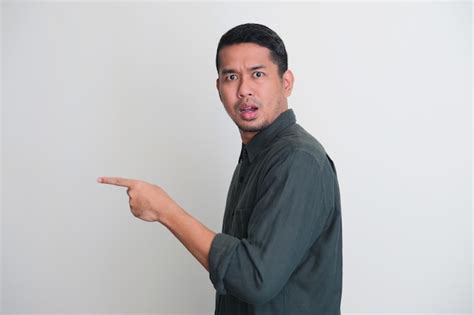 Premium Photo Side View Of Asian Man Pointing To The Left Side With Worried Expression