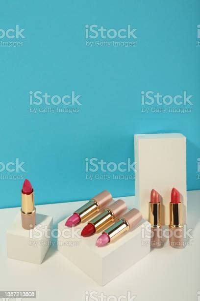 파란색 배경에 흰색 기하학적 연단에 다른 립스틱의 모형 브랜딩 및 패키징 프레젠테이션을 위한 배경 뷰티 및 메이크업 제품 컨셉