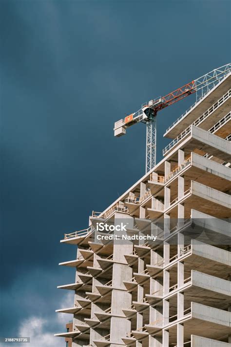 폭풍우가 몰아치는 하늘을 배경으로 건설 중인 다층 건물 위로 고층 타워 크레인 강철에 대한 스톡 사진 및 기타 이미지 강철