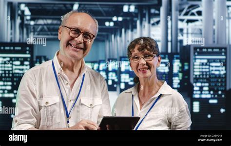 Colleagues In Data Center Using Laptop To Monitor Energy Efficient Rigs